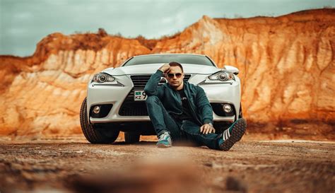 검은 재킷을 입은 남자와 검은 재킷을 입은 여자가 흰색 차 옆에 바닥에 앉아 있다 사진 Unsplash의 무료 자동차 이미지