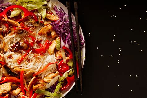 자피 한국 유리 국수 볶음 요리 검은 색 배경에 참깨 야채와 소스를 곁들인 조림 닭고기를 곁들인 한국유리 자페 국수 맨 위 보기입니다 재즈 아시아 요리 펀초이스 0명에 대한