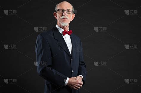 穿西装打红领带的老人影棚拍摄