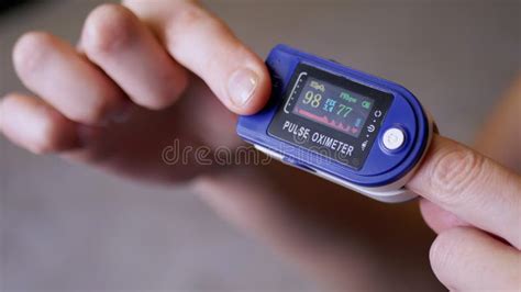 Female Hands Show Measures Pulse And Oxygen Saturation Using A Pulse Oximeter In Room Stock