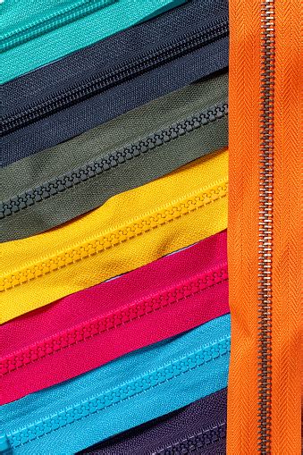 블루 데님 배경에 수제 바느질 테일러링을위한 슬라이더 패턴과 다채로운 플라스틱 및 금속 지퍼 줄무늬의 팩 많이 선택 적 초점을 닫습니다 0명에 대한 스톡 사진 및 기타