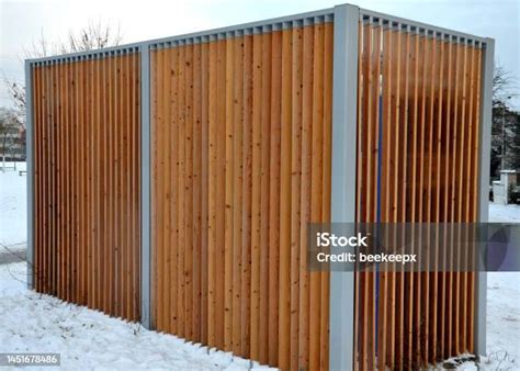 화학 화장실을 배치하기위한 폐쇄 케이지 보기 흉한 플라스틱 상자는 평평한 지붕과 벽에 나무 칸막이가있는 금속 집 안에 있습니다