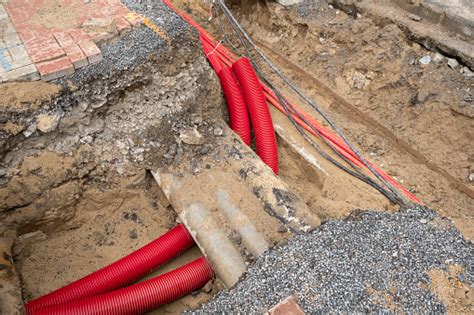 빨간색 골판지 파이프의 전기 케이블은 거리의 지하에 묻혀 있습니다 전기 케이블 인프라 설치 에너지 공급이 많은 건설 현장 0명에 대한 스톡 사진 및 기타 이미지 Istock
