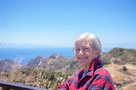 태양과 휴가를 즐기며 기쁨과 자유를 표현하는 웃는 노인 여성의 초상화 카나리아 제도 테 네리 페 의 산과 대서양을 배경으로 건강한 생활방식에 대한 스톡 사진 및 기타 이미지
