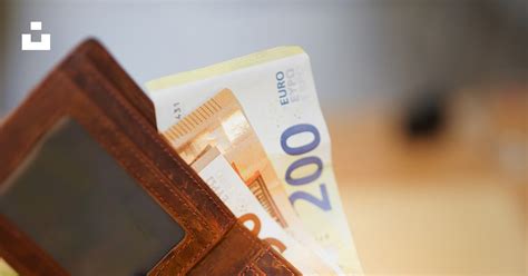 한 사람이 돈이 든 지갑을 들고 있습니다 사진 Unsplash의 무료 지불 이미지