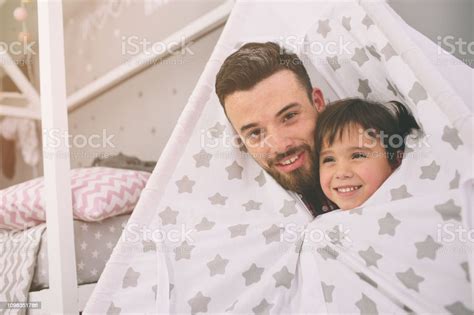 귀여운 작은 딸과 그녀의 잘생긴 젊은 아빠는 자녀의 방에 함께 놀고 있다 아빠와 아이가 시간을 보내고 함께 침실 바닥에 앉아있는 동안 가족에 대한 스톡 사진 및 기타 이미지