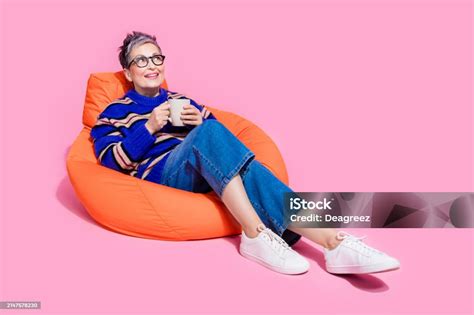 연금 수령자 여자 콩 주머니 커피 모습 빈 공간을 입은 전신 사진 분홍색 배경 고립 된 세련된 파란색 줄무늬 옷 50 54세에 대한 스톡 사진 및 기타 이미지 Istock