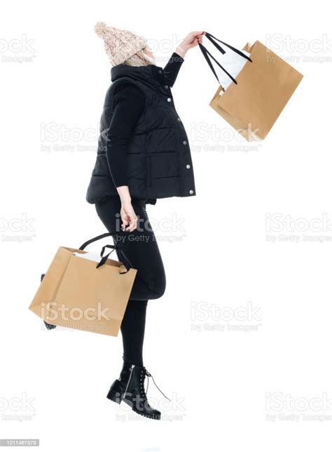 니트 모자를 쓰고 가방을 들고 흰색 배경 앞에서 점프하는 여성 쇼핑 중독 가방에 대한 스톡 사진 및 기타 이미지 가방 겨울 공중 Istock