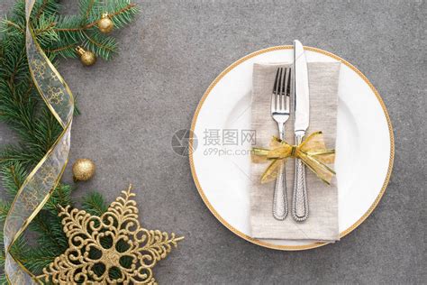 在圣诞球和金星装饰的常青树枝附近用金丝带包裹着叉子和刀子的高架视野高清图片下载 正版图片507460116 摄图网