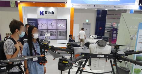 상업 농업용 대형 드론 살펴보는 관람객