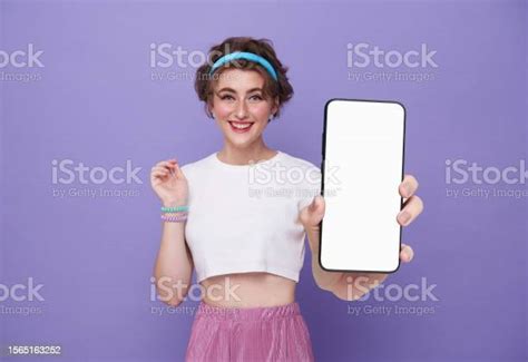 흥분한 여자는 보라색 배경에 고립된 빈 화면의 스마트폰 모형을 들고 있다 소셜 미디어 응용 프로그램에 대한 휴대 전화 모형입니다 행복에 대한 스톡 사진 및 기타 이미지
