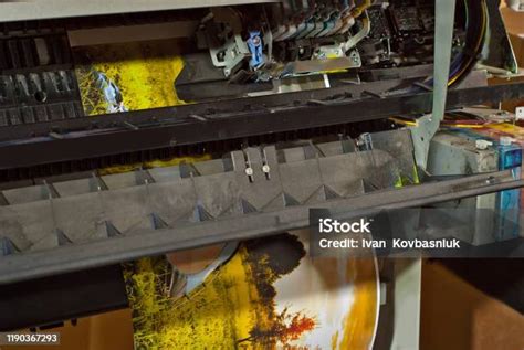 작업장에서 오래된 깨진 프린터 프린터 청소 및 교정 개념입니다 사진에서 일몰 텐트와 녹색 잔디입니다 인쇄 장비에 인쇄 된 그림 같은 자연 사진입니다 개념에 대한 스톡 사진