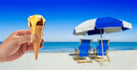 흐릿한 일광욕용 라운저 앞에서 녹는 아이스크림과 은빛 모래 위에 비치 우산을 들고 손을 잡으세요 경관에 대한 스톡 사진 및 기타 이미지 Istock