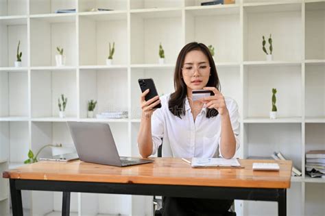 Confused Asian Female Having A Problem On Her Mobile Banking