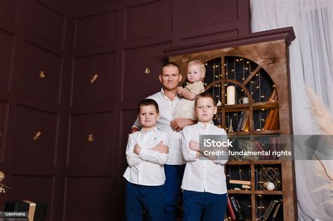 남자와 세 명의 아이들이 방에 서 있다 흰색 셔츠 교복을 입은 남자들 30 34세에 대한 스톡 사진 및 기타 이미지 30 34세 35 39세 가족 Istock