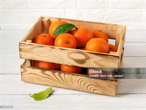 부엌 테이블에 달콤한 잘 익은 오렌지 귤 나무 상자 나무 상자에 신선한 감귤류 과일과 채소를 위한 친환경 소박한 스타일의 용기