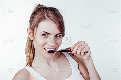 美丽的女孩用牙刷清洁洁白的牙齿