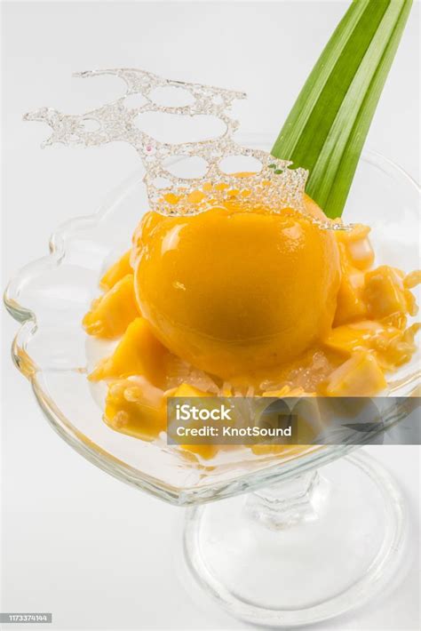 망고와 끈적 끈적한 쌀 조각으로 장식 된 맑은 유리 컵에 망고 끈적 끈적한 쌀 아이스크림 은 흰색 배경에 눈송이의 형태로 설탕으로 장식 가지 식물 부위에 대한 스톡 사진 및