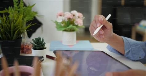 편안한 직장에서 빈 화면이 있는 스타일러스 펜과 디지털 태블릿을 들고 있는 남자의 모습을 닫습니다 사진 Unsplash의 태국 이미지