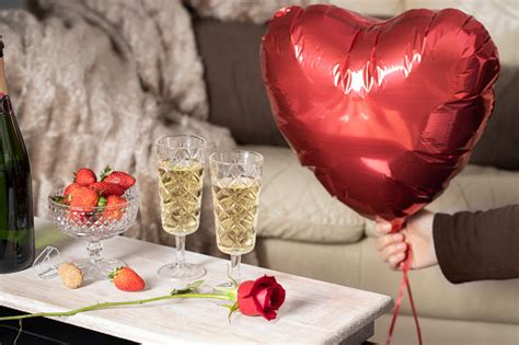 로맨틱 한 데이트 개념입니다 거실에서 베이지 색 소파에 두 개의 샴페인 잔과 딸기 세인트 발렌타인 데이 축하를위한 큰 빨간 하트 모양의 공 0명에 대한 스톡 사진 및 기타