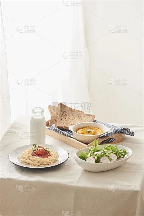 早餐桌上 意大利面配萝卜沙拉配南瓜泥面包牛奶摆在桌上素材 花瓣网
