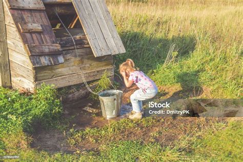 화창한 여름 날 우물에 있는 아이가 양동이에 물을 그리고 금속 머그잔에서 음료를 마시며 4 5세에 대한 스톡 사진 및 기타 이미지 4 5세 8 9 살 강철 Istock