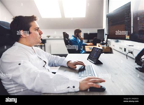 Side View Waist Up Of Two It Programmers Coding In A Bright Office With