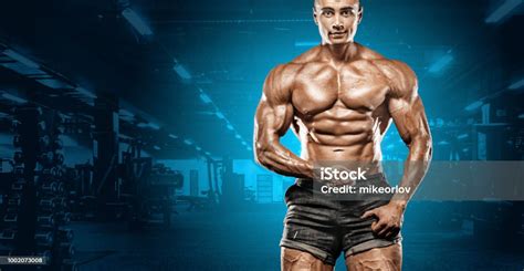 잔인 한 강한 근육 질의 보디 운동 남자 체육관 배경에 근육을 펌핑 운동 보디 빌딩 개념입니다 스포츠 영양 광고 공간에 복사