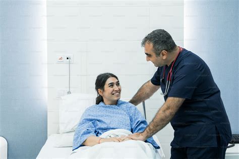 병원 침대에 누워 있는 여자 옆에 서 있는 남자 사진 Unsplash의 건강 이미지