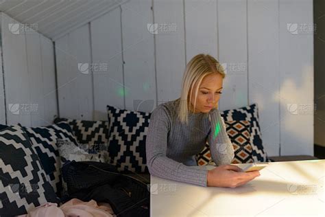 年轻漂亮的白人女人在家里用手机