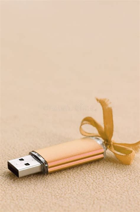 Orange Usb Flash Memory Card With A Blue Bow Lies On A Blanket Of Soft And Furry Light Orange