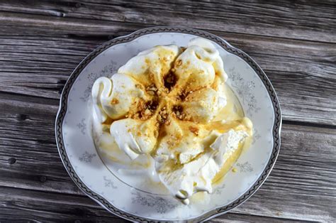 캐러멜 소스를 곁들인 풍부한 바닐라 캐러멜 아이스크림에 캐러멜 처리 된 헤이즐넛 조각을 얹고 냉동 및 제공 준비 완료 여름 및 휴일 컨셉 0명에 대한 스톡 사진 및 기타