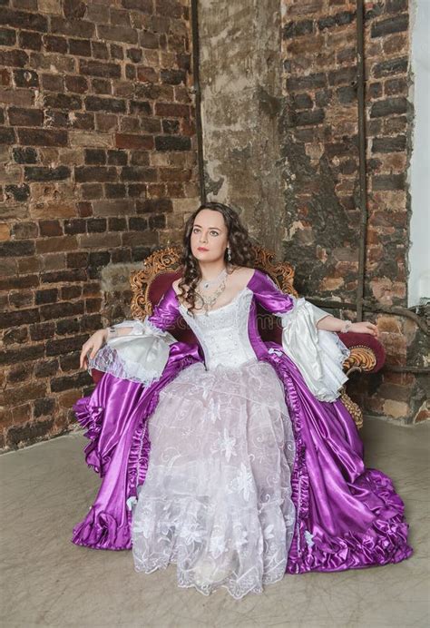 красивая женщина в белом и фиолетовом рококо стиле средневековый платье сидит в кресле у