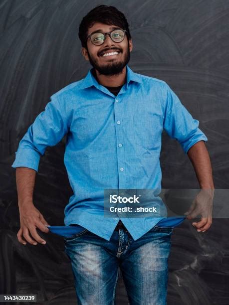파란색 셔츠와 안경을 쓰고 학교 칠판 배경에 빈 주머니를 상징적으로 보여주는 인도 남성의 사진 20 24세에 대한 스톡 사진 및 기타 이미지 Istock