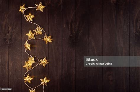 고급 우아한 새해 배경 장식 테두리 상단 보기 수직으로 어두운 갈색 나무 보드에 불타는 황금 별과 조명 갈란드 장식품에 대한 스톡 사진 및 기타 이미지 Istock