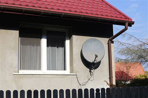 빨간 기와 지붕을 가진 회색 집 정면에 위성 접시 나무 울타리가 있는 시골 마을 건축 0명에 대한 스톡 사진 및 기타 이미지 0명 건물 정면 건축 Istock
