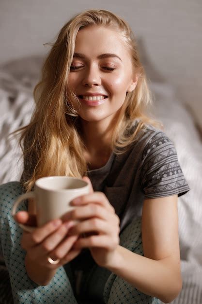 Premium Photo Blonde Holds A Cup Of Coffee In The Morning