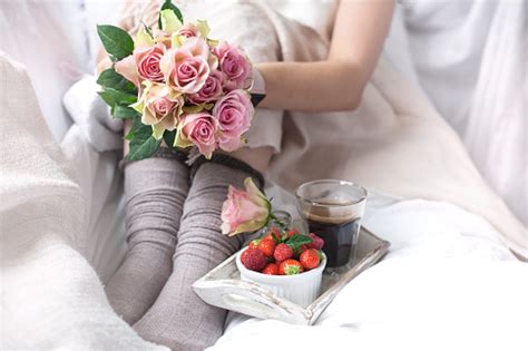 침대 딸기의 열매와 향기로운 모닝 커피에 여자의 손에 핑크 장미 꽃다발 로맨틱 침대에서 아침 식사입니다 빈티지 사진입니다 공간 복사 가정의 방에 대한 스톡 사진 및 기타