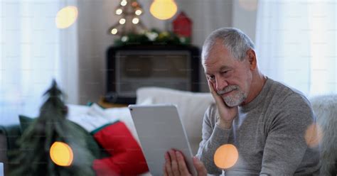 크리스마스에 실내 테이블에 태블릿을 들고 있는 슬프고 외로운 노인의 초상화 고독 개념 사진 Unsplash의 앉아 이미지