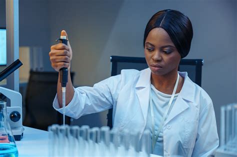 현대 실험실에서 자동 피펫으로 작업하는 실험실 코트를 입은 젊은 아름다운 아프리카 계 미국인 과학자 25 29세에 대한 스톡 사진 및 기타 이미지 Istock