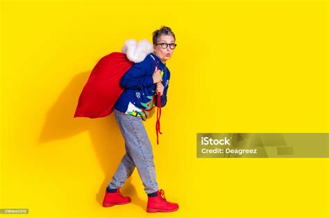 귀여운 매력적인 노인 여자가 파란색 유행 옷을 입고 부츠는 노란색 배경에 고립 된 빨간 가방을 운반합니다 50 54세에 대한 스톡 사진 및 기타 이미지 Istock