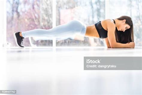 완벽 한 판자입니다 전체 길이 스포츠 체육관에서 창 앞에 서 있는 동안 판자를 하 고 있는 젊은 아름 다운 여자의 모습 널판지에 대한 스톡 사진 및 기타 이미지 Istock
