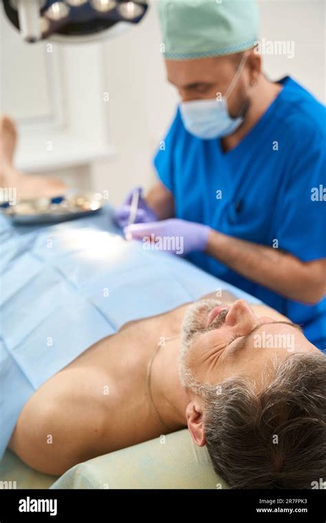 Man On Operating Table Who Is Injected By Doctor Stock Photo Alamy