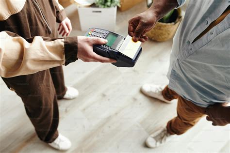 남성 노동자가 보유한 지불 단말기에 신용 카드를 들고 로더의 작업을 지불하는 아프리카 민족의 청년의 손 사진 Unsplash의 회원 자격 이미지