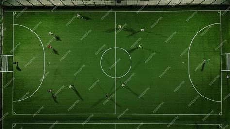 Вид сверху на мини футбольное поле и футболистов с дрона Премиум Фото