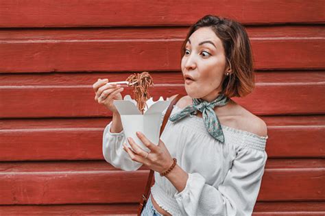 골판지 상자에서 동양 매운 국수를 먹는 행복한 아시아 소녀 테이크 아웃 길거리 음식 개념 30 34세에 대한 스톡 사진 및 기타