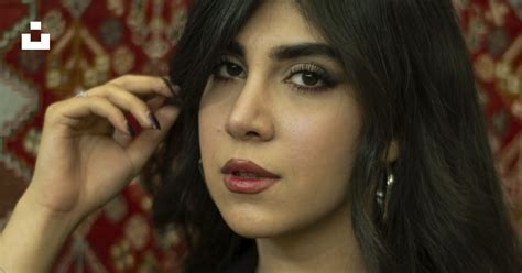 검은 양복을 입은 여성이 사진을 찍기 위해 포즈를 취하고 있다 사진 Unsplash의 무료 테헤란 이미지