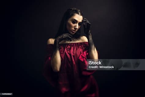 검은 배경 앞에서 얼굴과 손에 빨간 드레스와 무서운 화장을 한 여성 갈색 머리에 대한 스톡 사진 및 기타 이미지 갈색 머리 관능 나이 Istock
