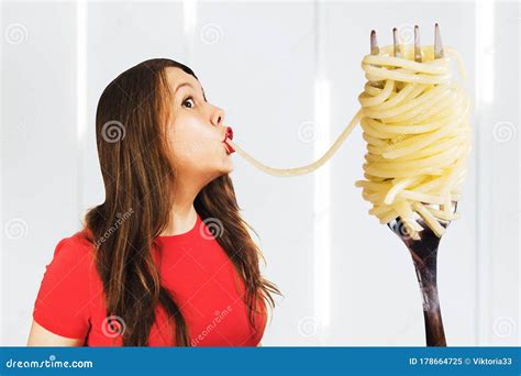 Young Woman Sucks Huge Pasta And Spaghetti From A Big Fork Stock Image