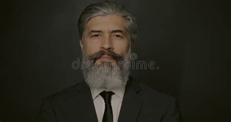 Close Up Portrait Of Serious Businessman Appearing On Black Background Then Disappearing Again